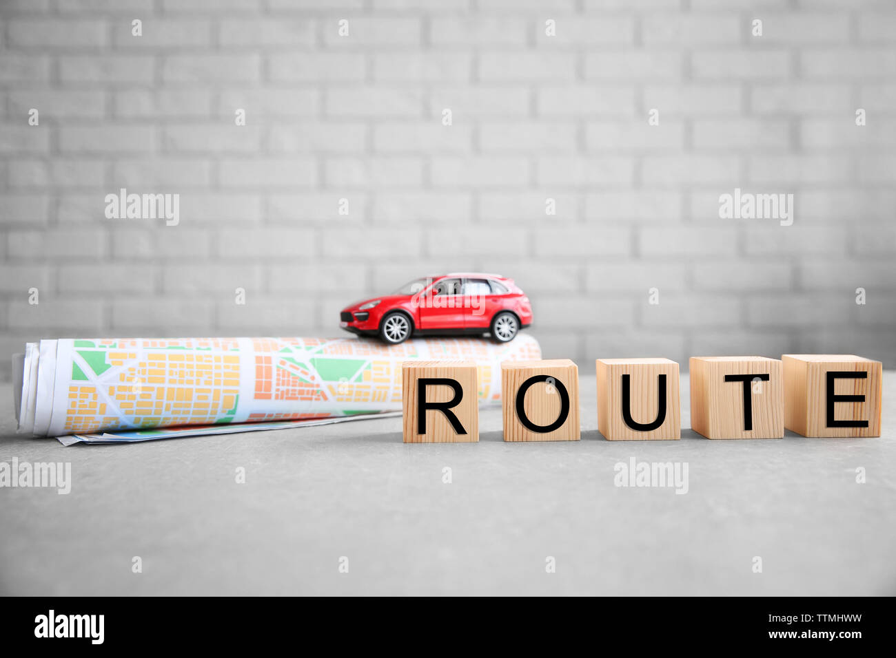 Cubes with word ROUTE, map and toy car on brick wall background Stock ...