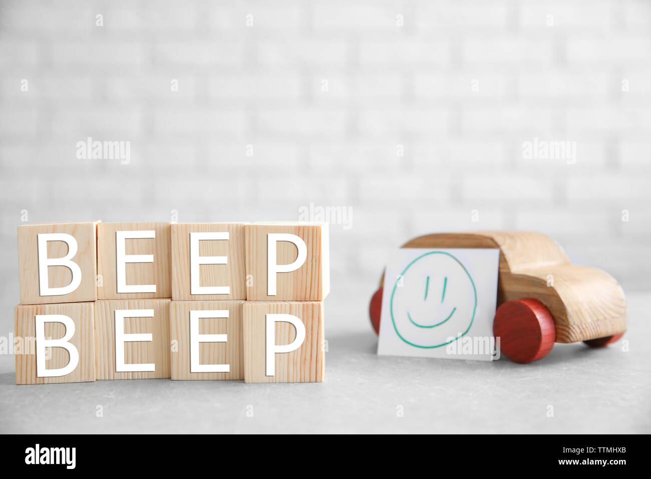 Cubes with words BEEP BEEP and toy car on brick wall background Stock ...