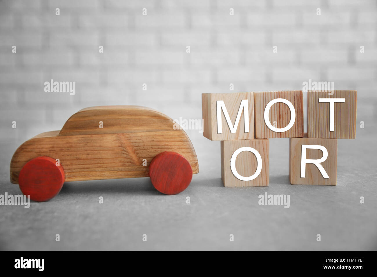 Cubes with word MOTOR and toy car on brick wall background Stock Photo ...