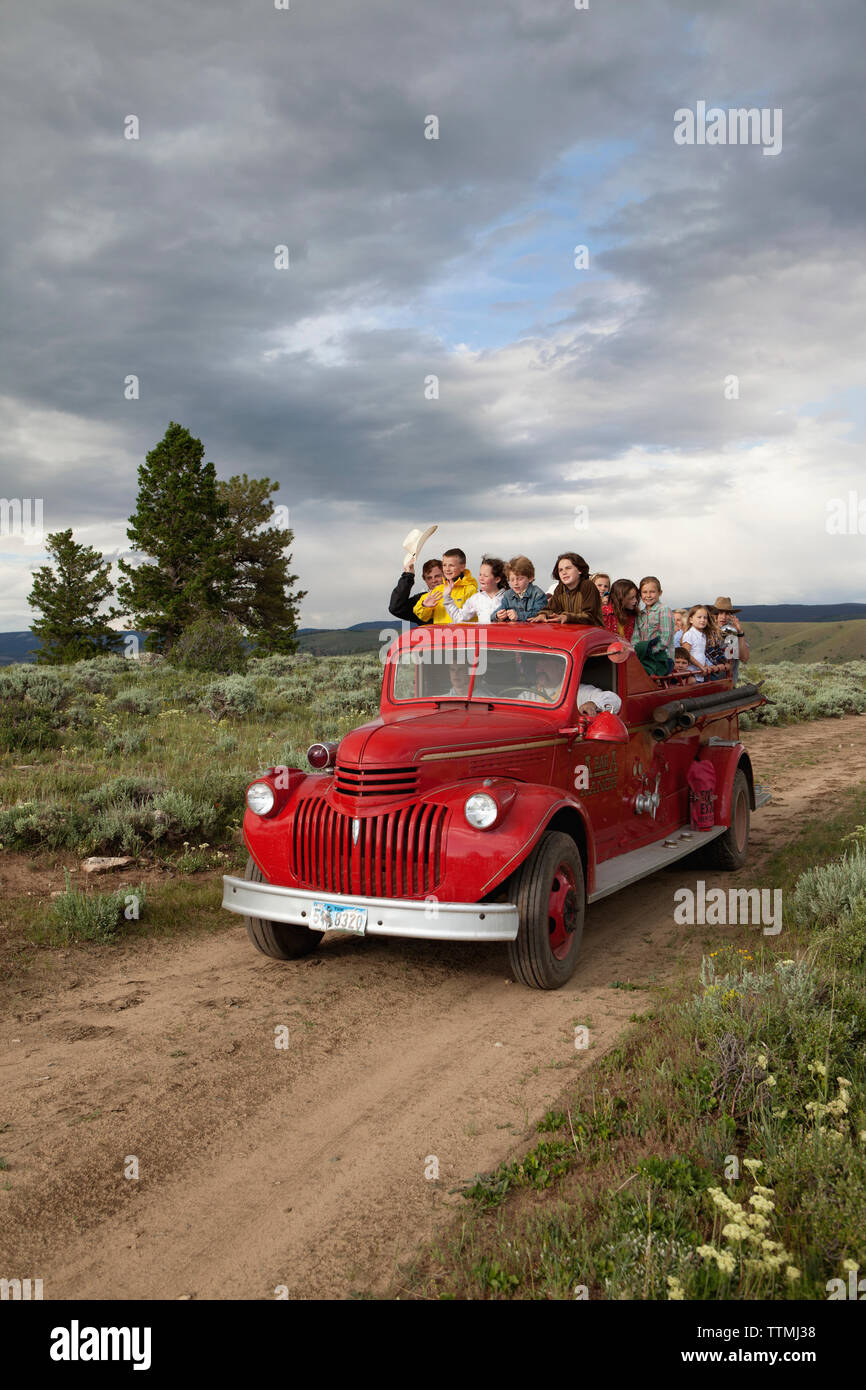 USA, Wyoming, Encampment, kids ride an old restored firetruck to a ...