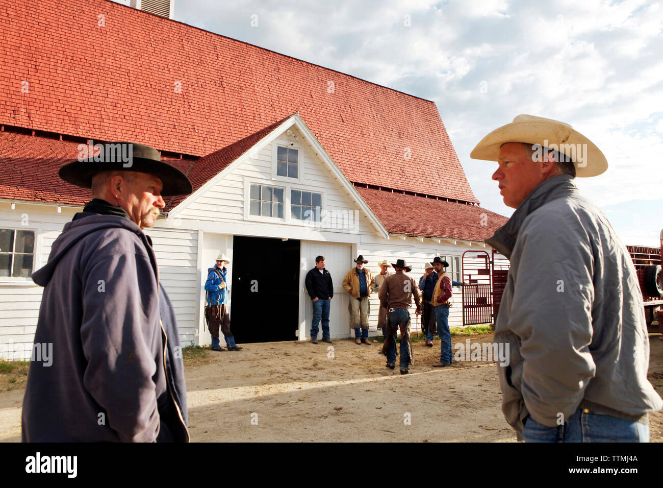 USA, Wyoming, Encampment, cowboys stand around talking before heading ...