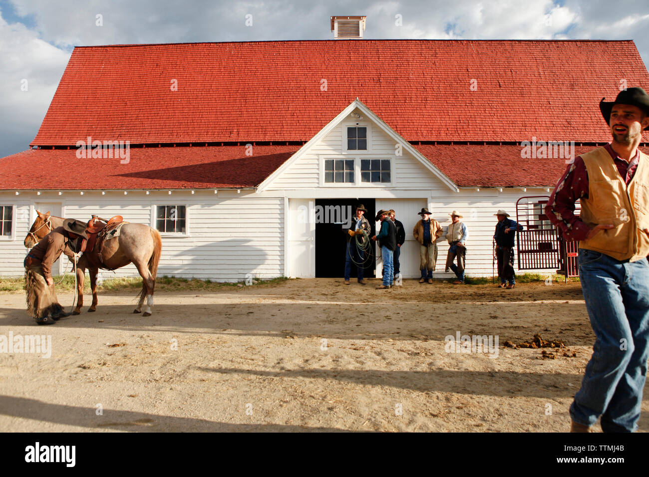 USA, Wyoming, Encampment, cowboys stand around talking before heading ...