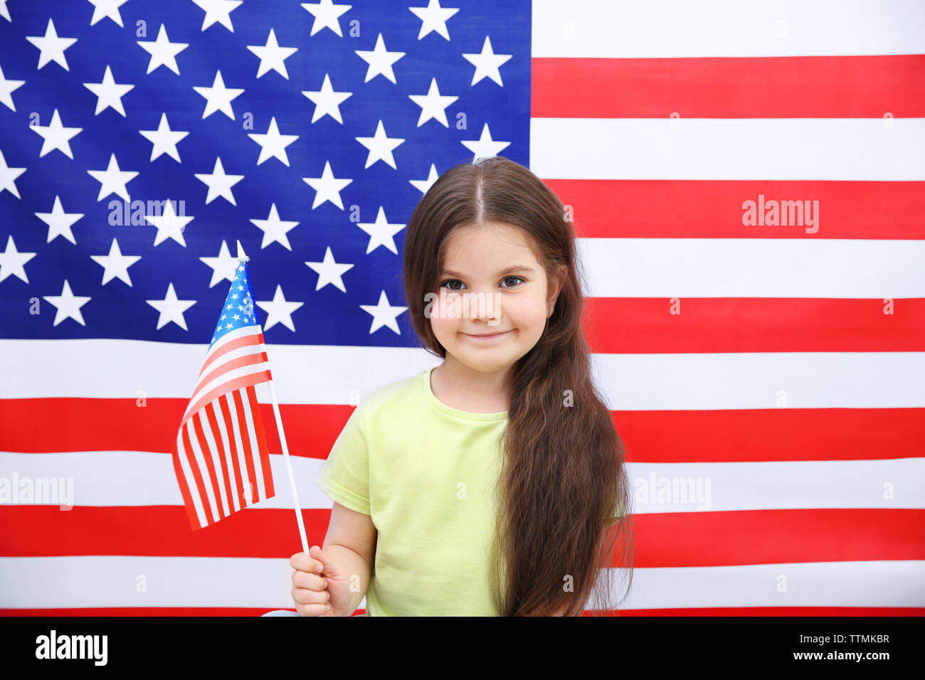 Cute little girl on American flag background Stock Photo - Alamy