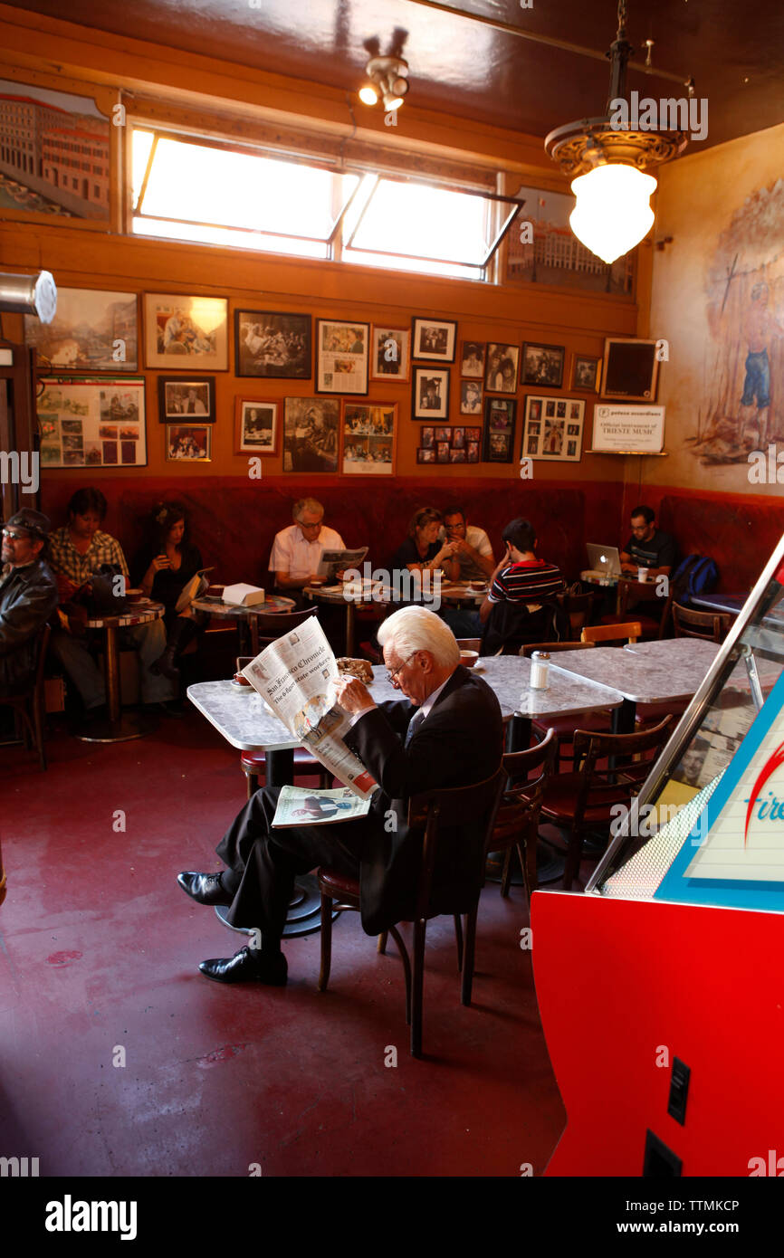 USA, California, San Francisco, a man ready the newspaper at at table ...