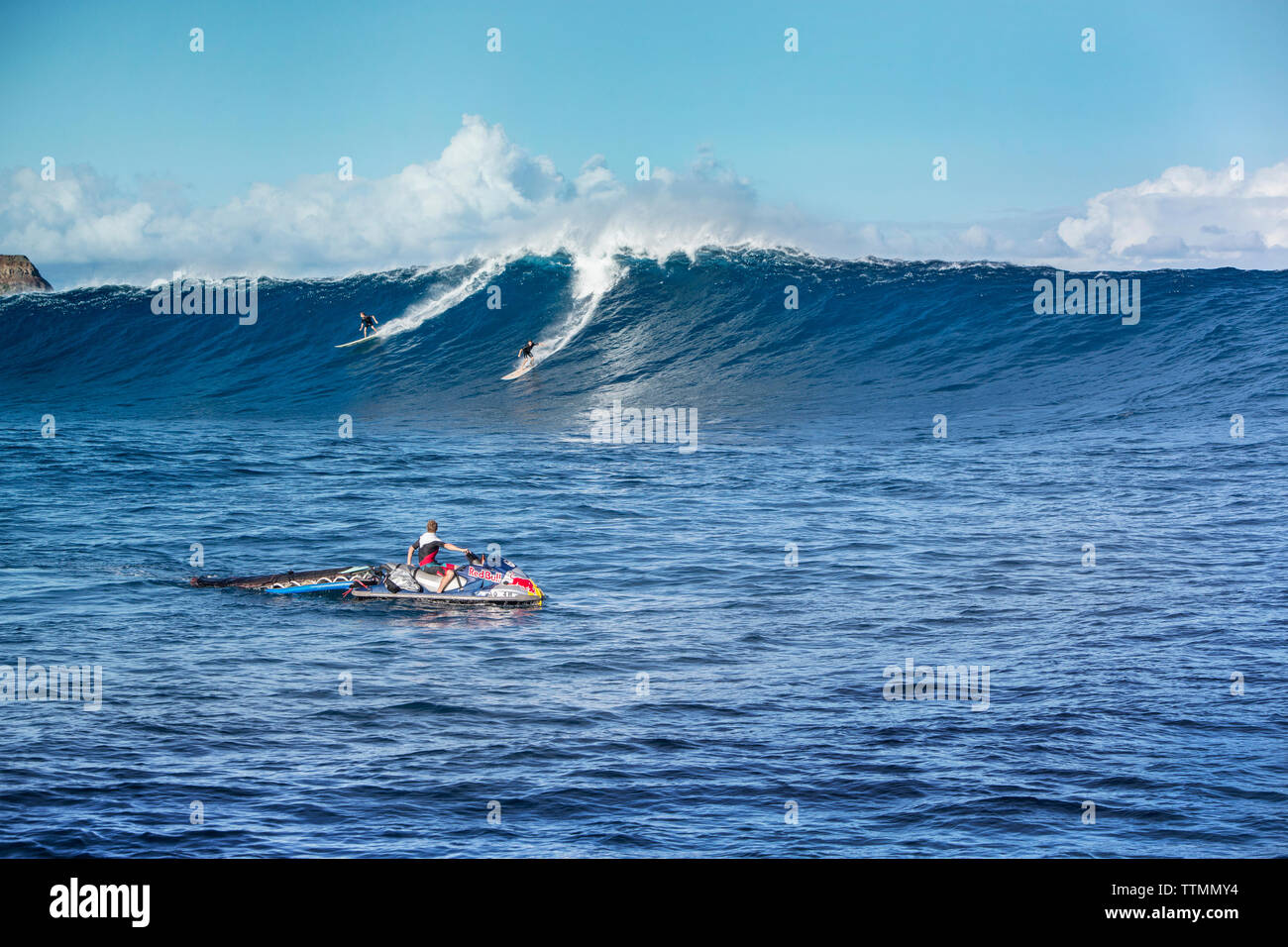 USA, HAWAII, Maui, Jaws, big wave surfers taking off on a wave at Peahi ...