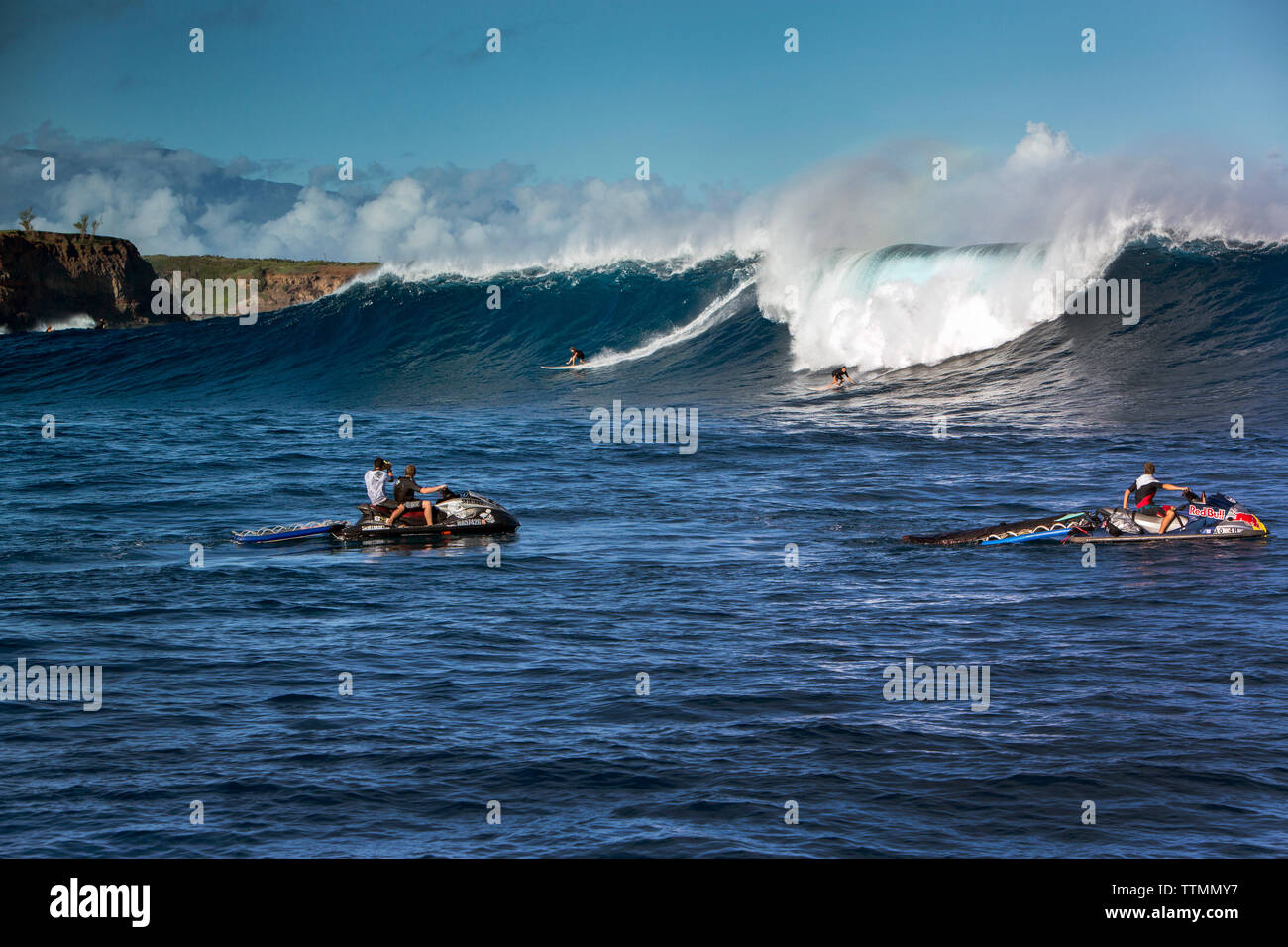 USA, HAWAII, Maui, Jaws, big wave surfers taking off on a wave at Peahi ...