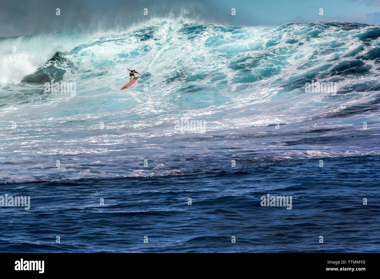 USA, HAWAII, Maui, Jaws, big wave surfers taking off on a wave at Peahi ...