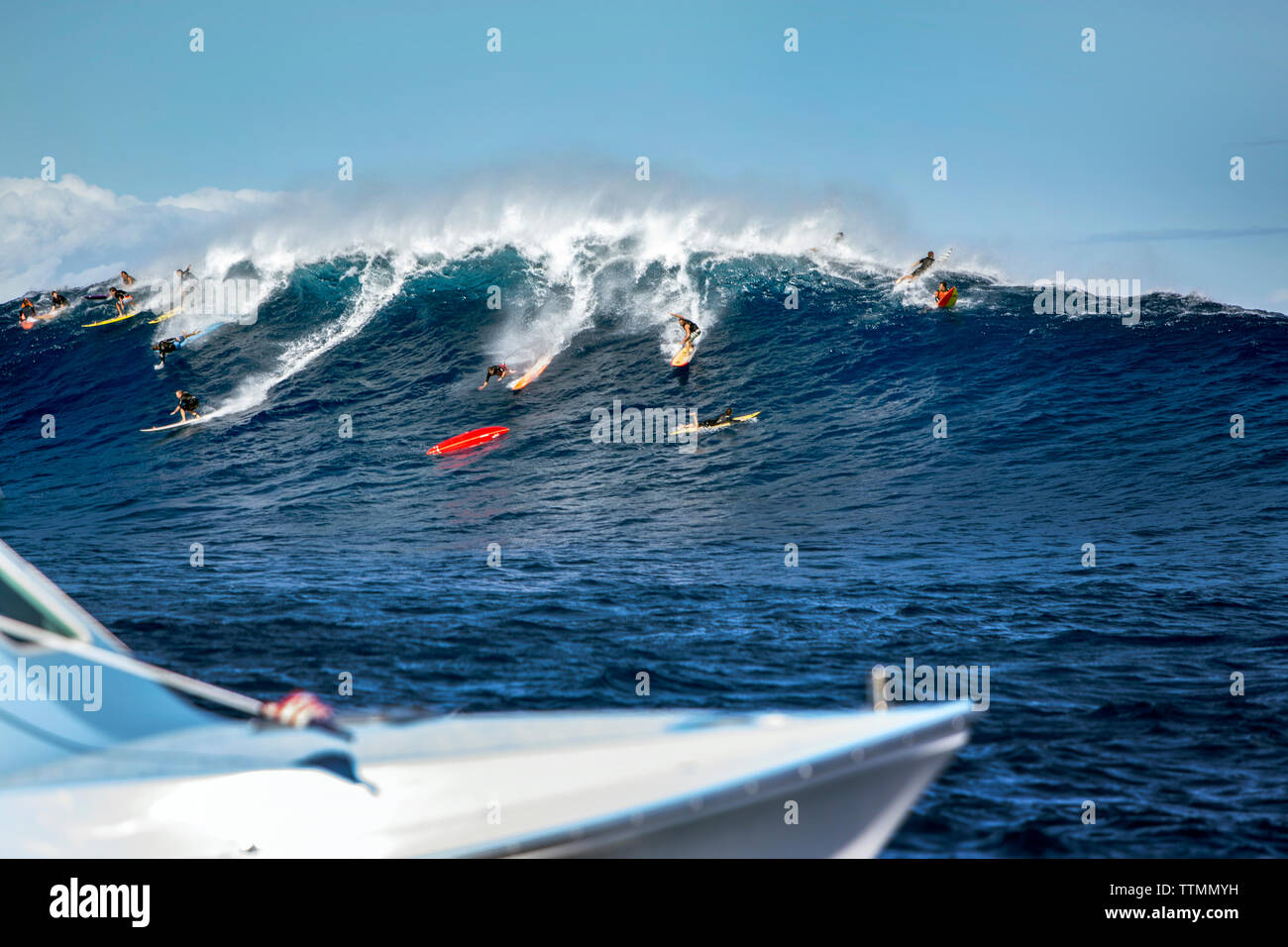 USA, HAWAII, Maui, Jaws, big wave surfers taking off on a wave at Peahi ...