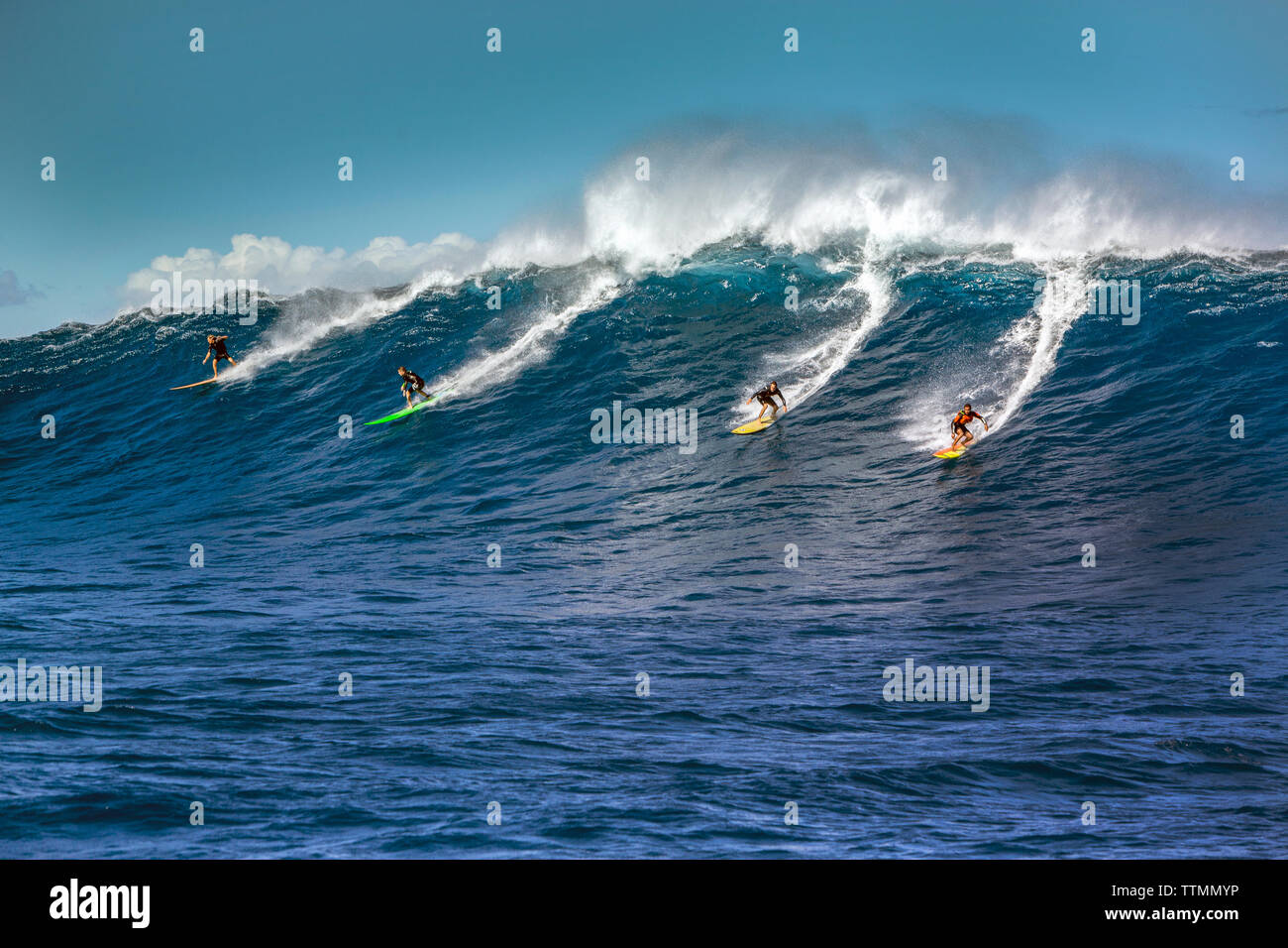 USA, HAWAII, Maui, Jaws, big wave surfers taking off on a wave at Peahi ...