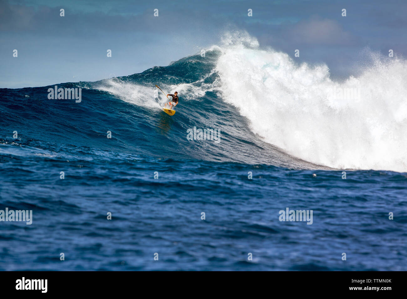 USA, HAWAII, Maui, Jaws, big wave surfers taking off on a wave at Peahi ...