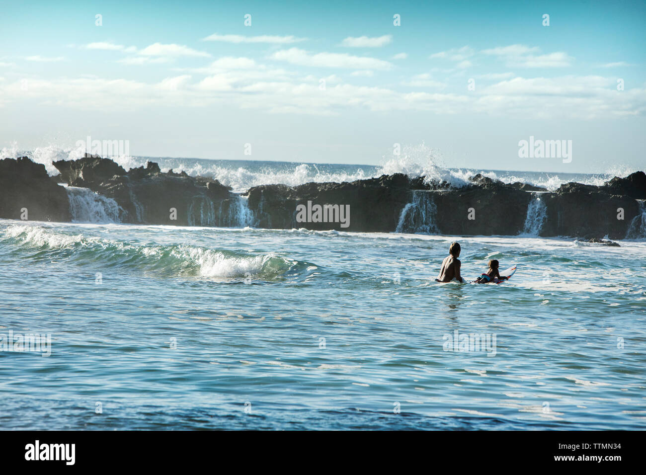 HAWAII, Oahu, North Shore, a man teaching his young son to surf in ...