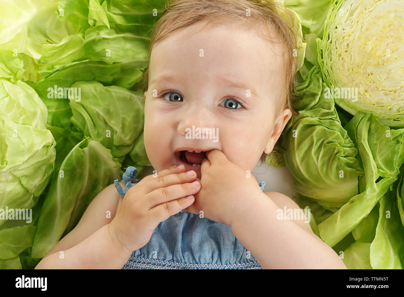 Cute baby girl in cabbage, closeup Stock Photo - Alamy