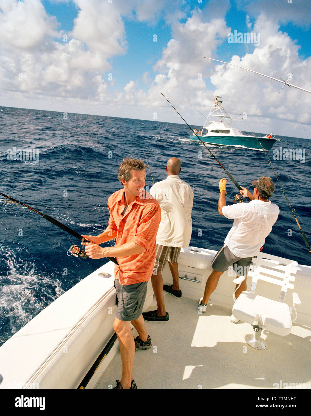 USA, Florida, three men fishing on the back of a boat, Islamorada Stock ...