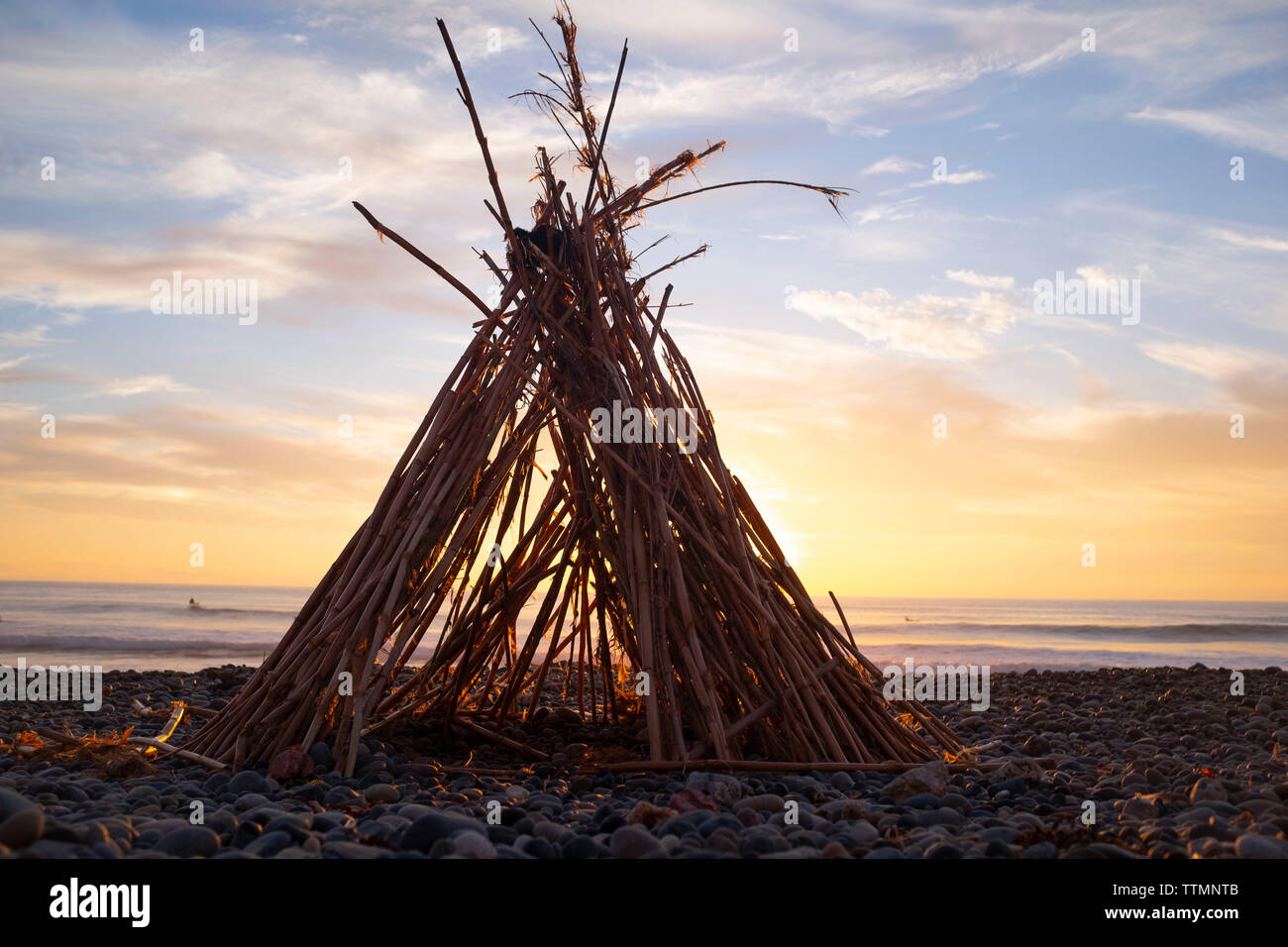 Bamboo teepee on rocky beach Stock Photo - Alamy