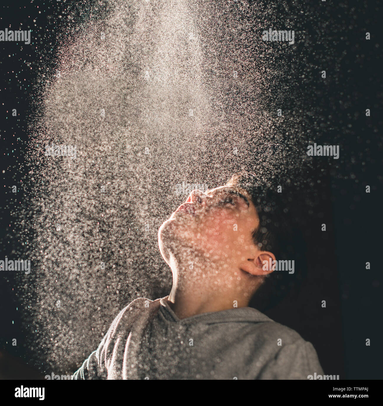 Snow falling on boy against black background Stock Photo - Alamy