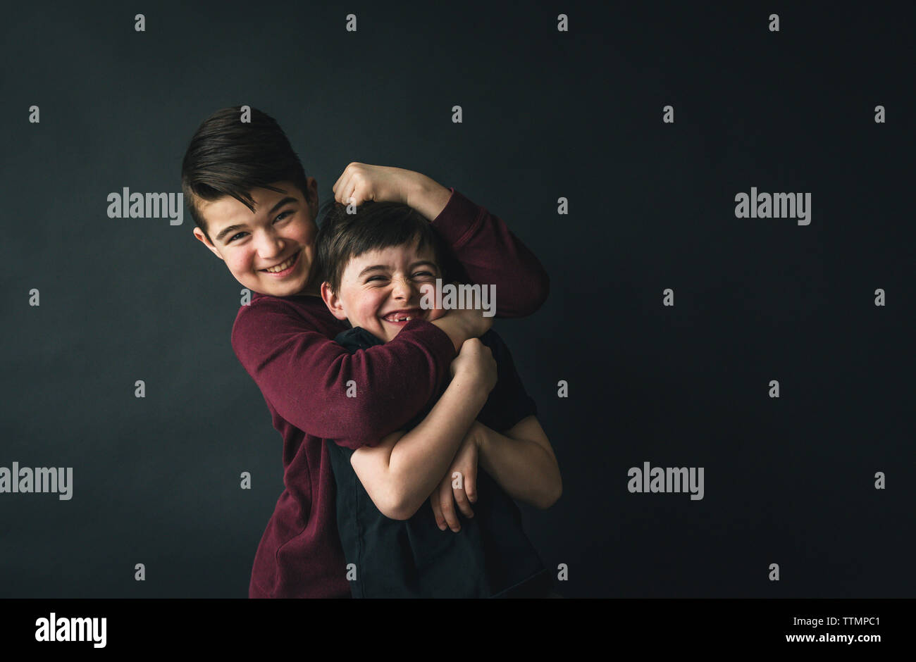 Portrait of two happy brothers against red background Stock Photo - Alamy