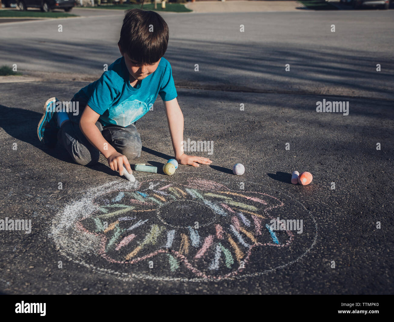 Boy drawing with chalk on asphalt Stock Photo - Alamy