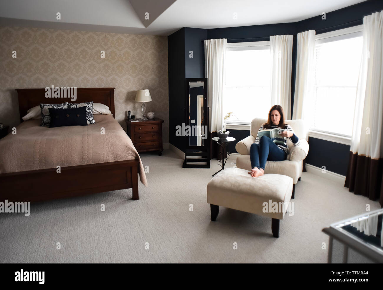 Woman in chair reading book hi-res stock photography and images - Alamy