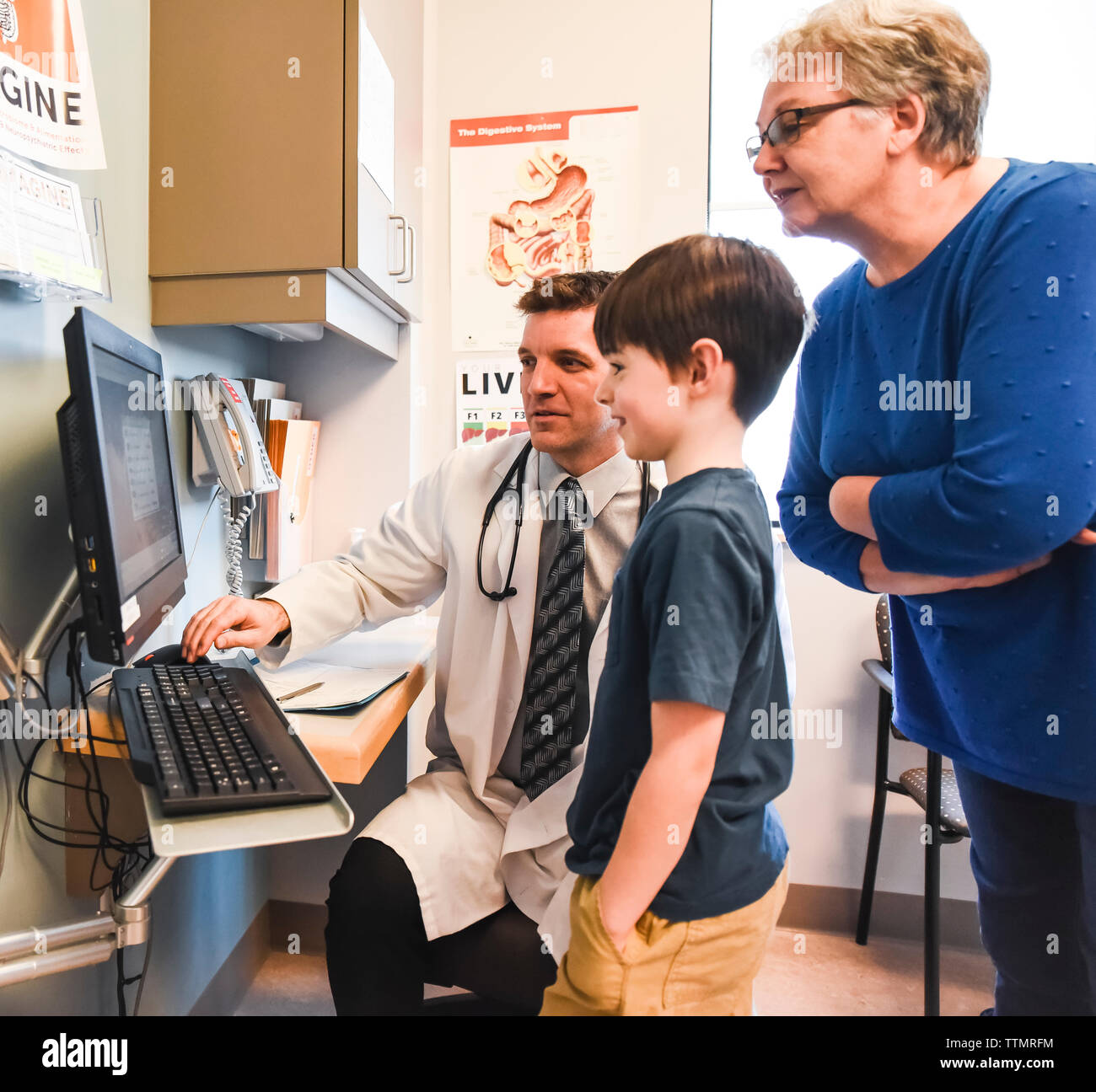 Doctor showing child and older woman information on computer screen ...