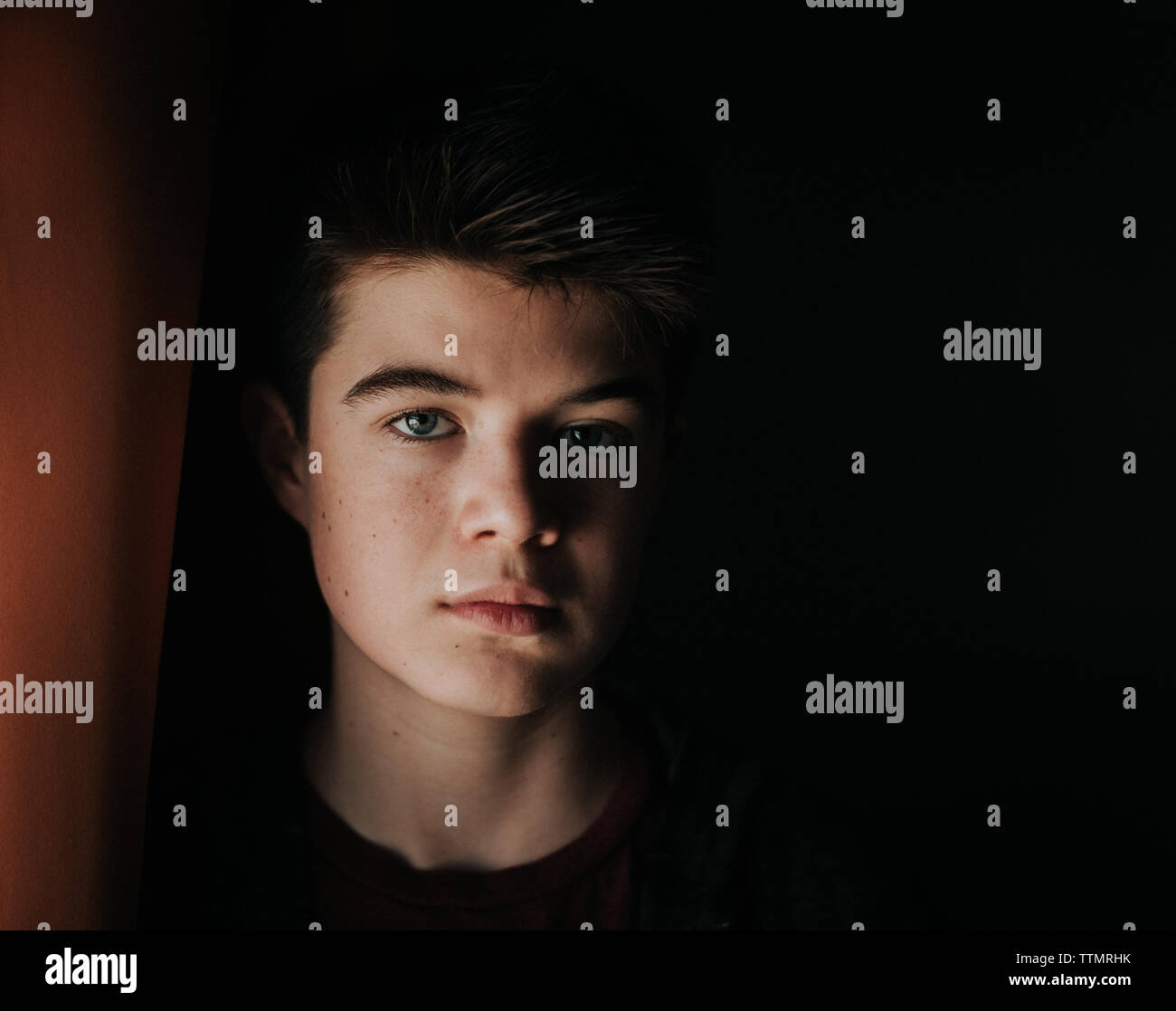 Close up portrait of teenage boy in dramatic window light Stock Photo ...