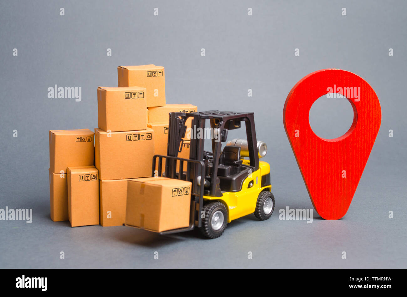 Yellow Forklift truck with cardboard boxes and a red position pin ...