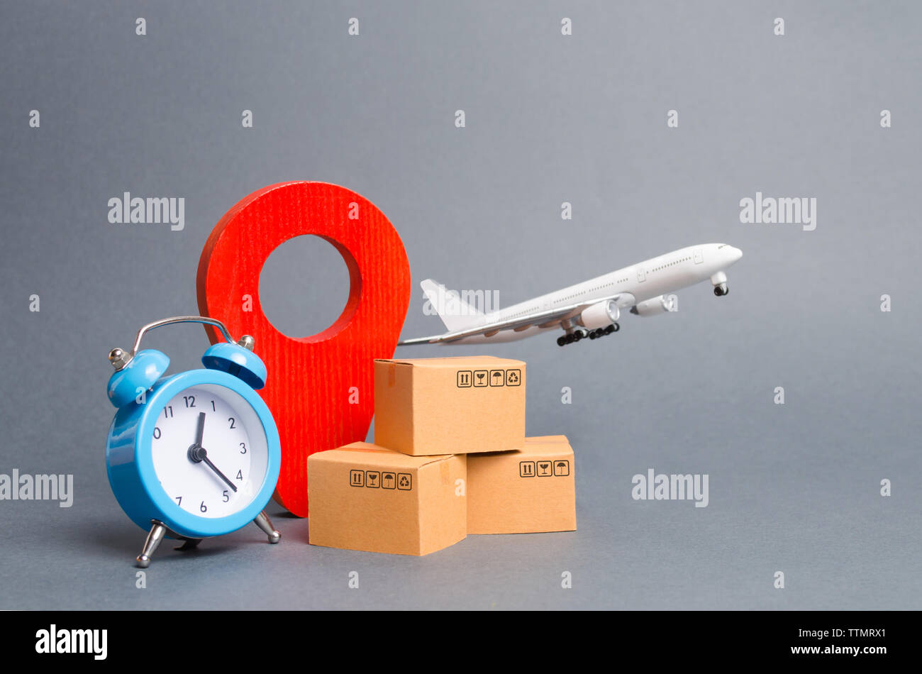 Airplane and stack of cardboard boxes, red position pin and blue alarm ...