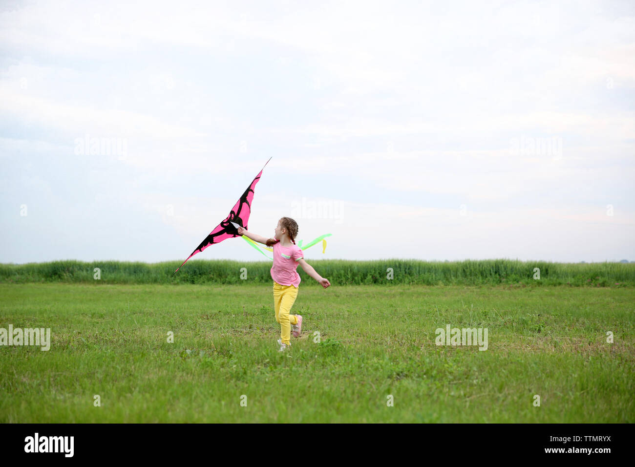 Cute girl playing with kite outdoor Stock Photo - Alamy