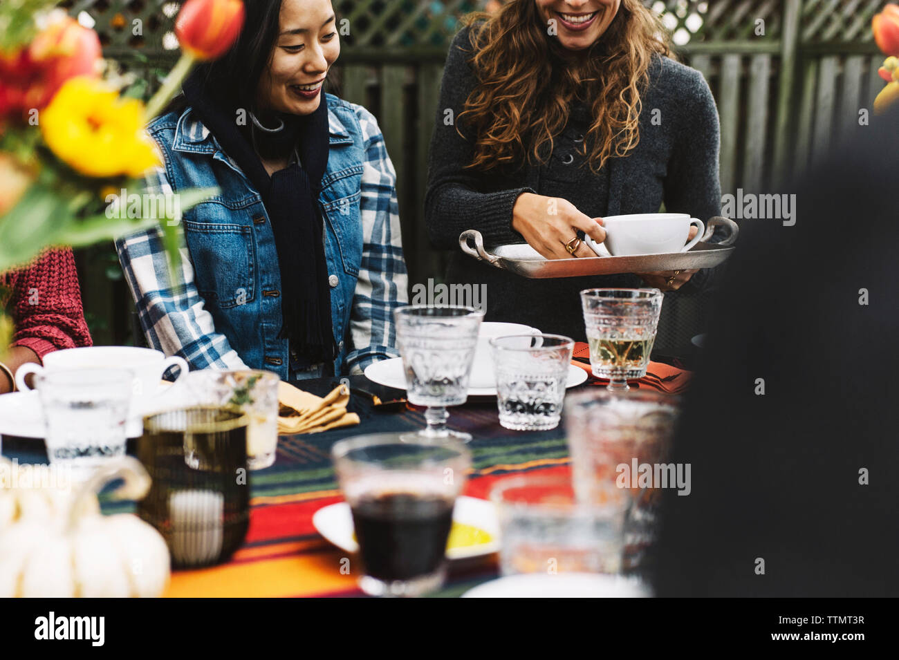 Happy friends standing at table in backyard Stock Photo - Alamy