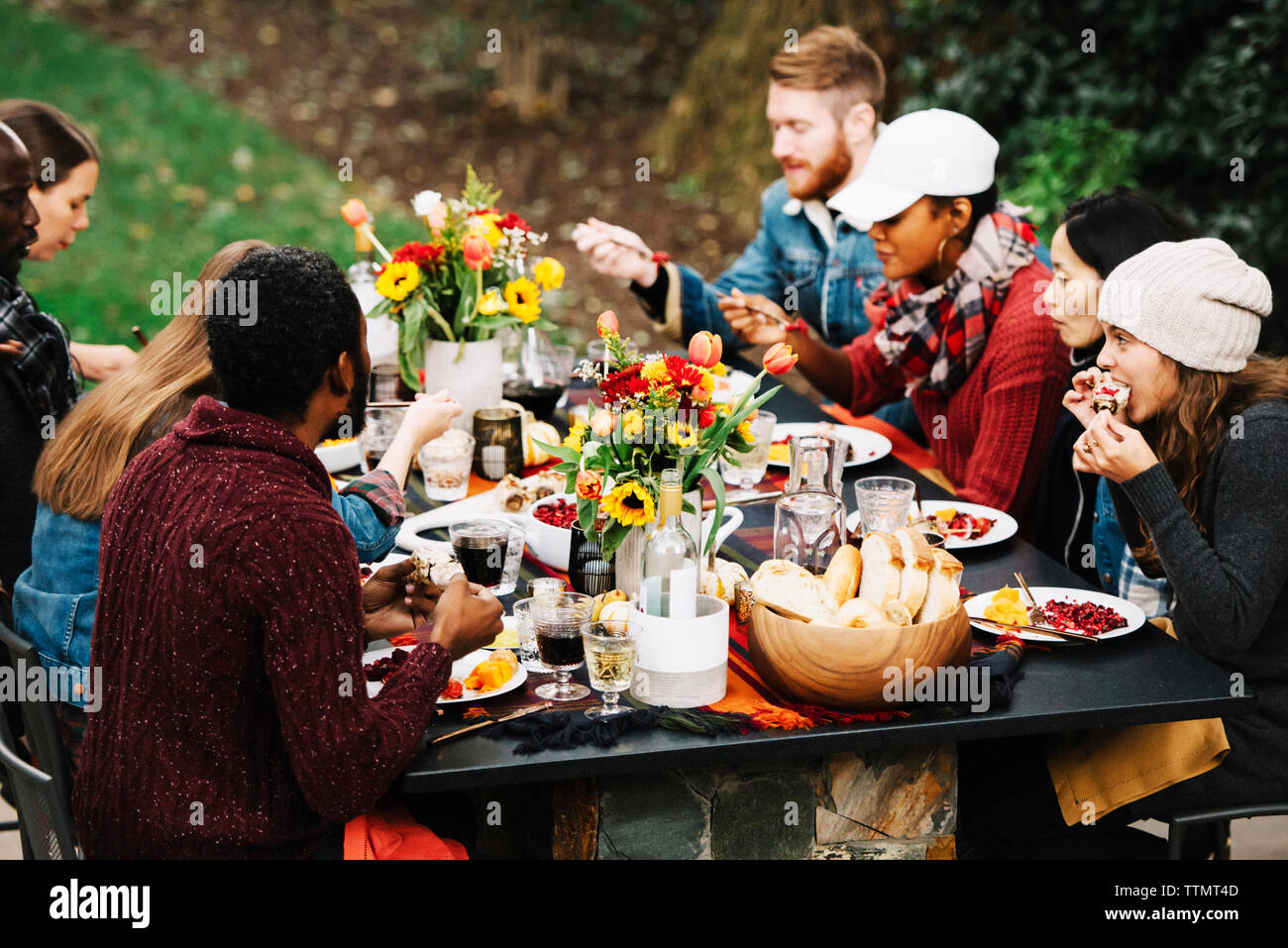 High angle view of friends eating food while sitting at dining table in ...