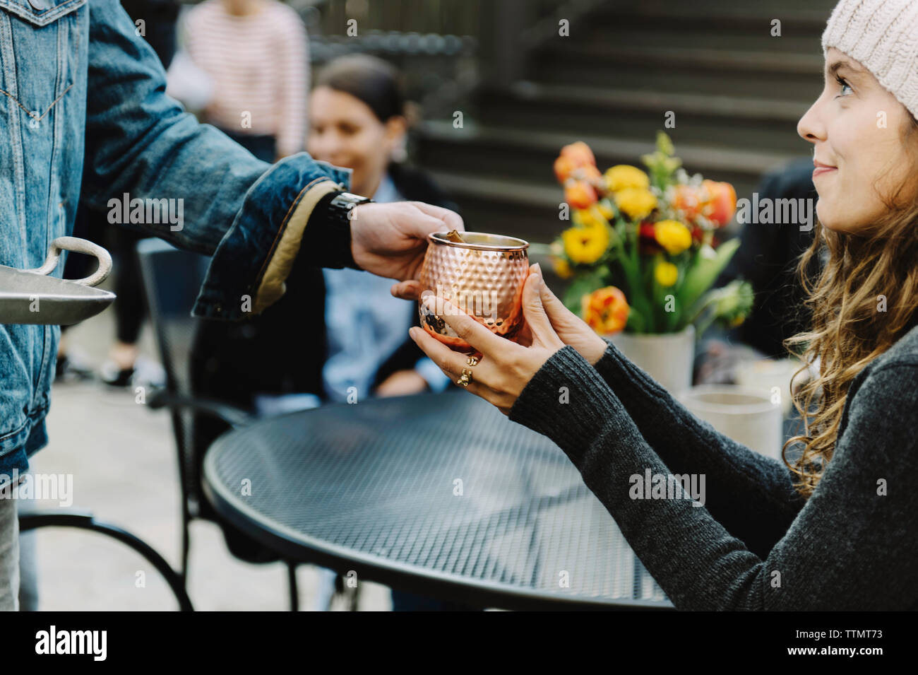Man giving drink to friend in backyard Stock Photo - Alamy