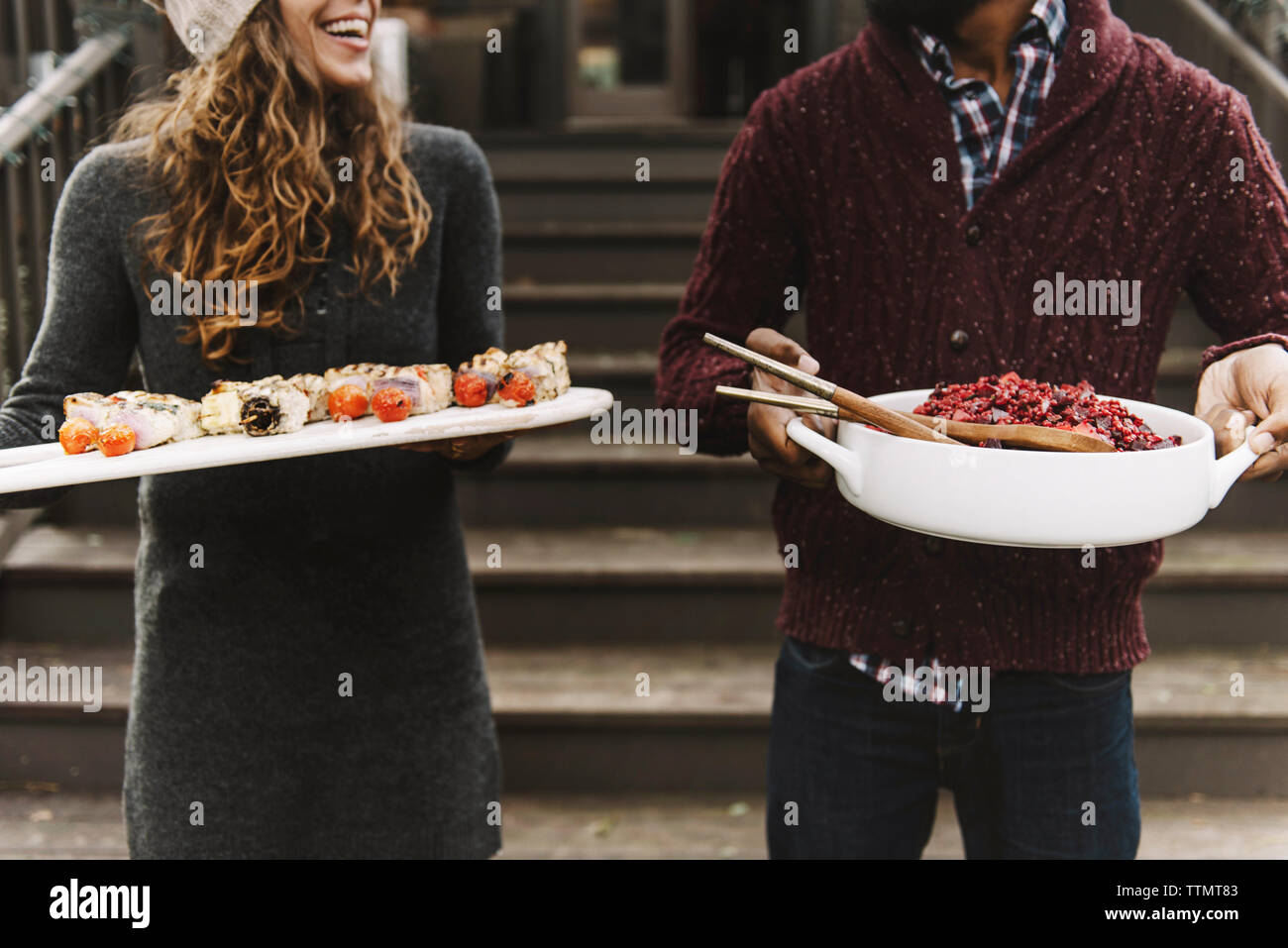 Happy friends carrying food in bowl and tray Stock Photo - Alamy