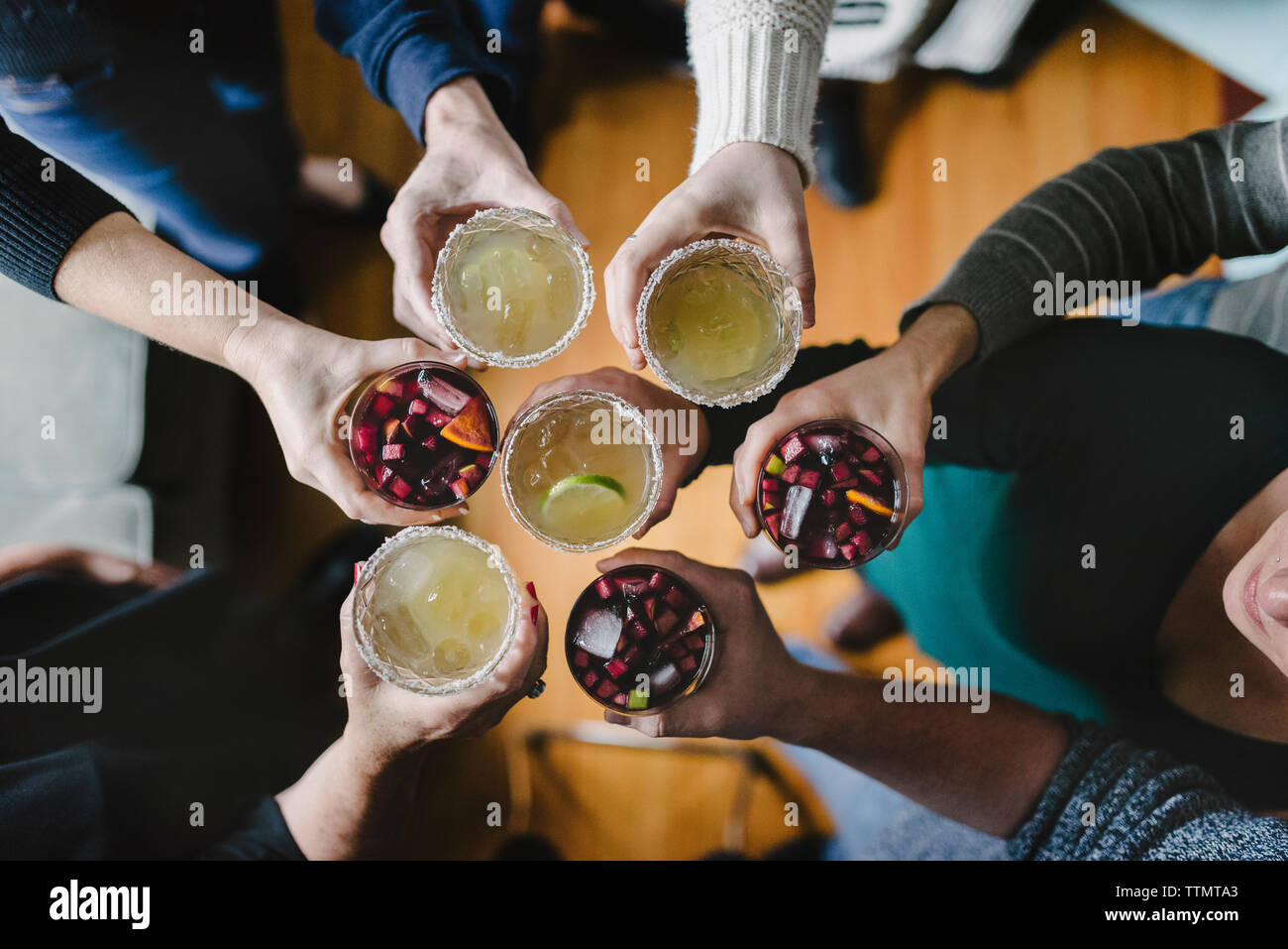 Overhead view of friends toasting drinks during social gathering at ...
