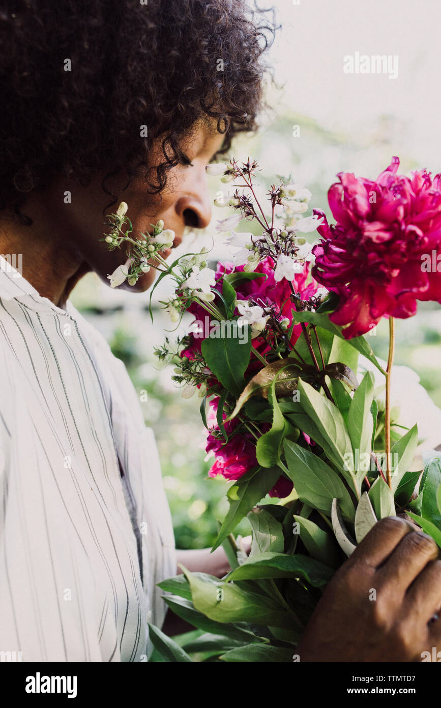Mature woman smelling fresh flowers in garden Stock Photo - Alamy