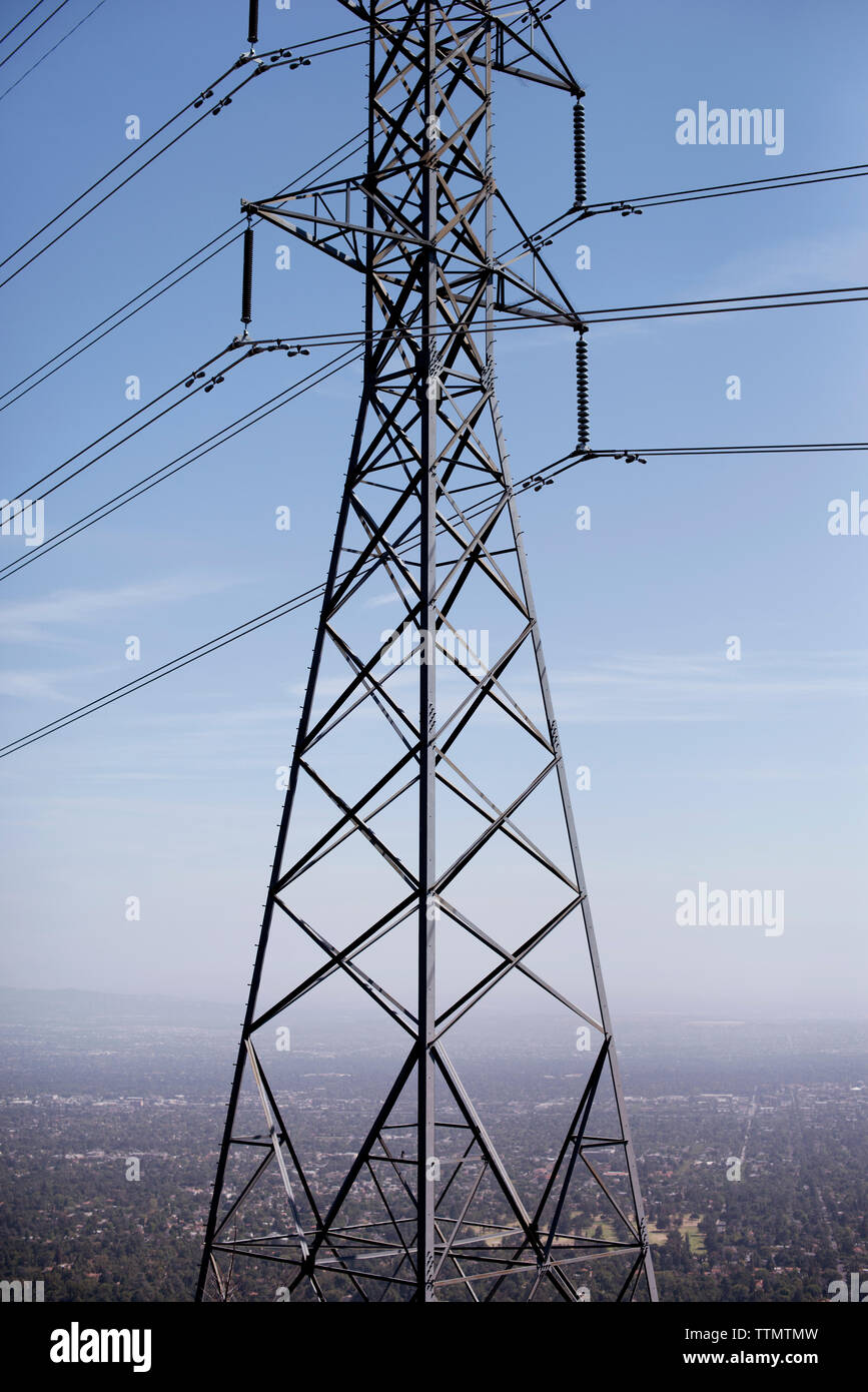 View of electricity pylon with forest in background Stock Photo - Alamy