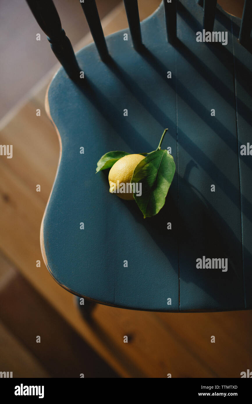 Yellow Lemon with green leaf laid on top of a blue chair Stock Photo ...