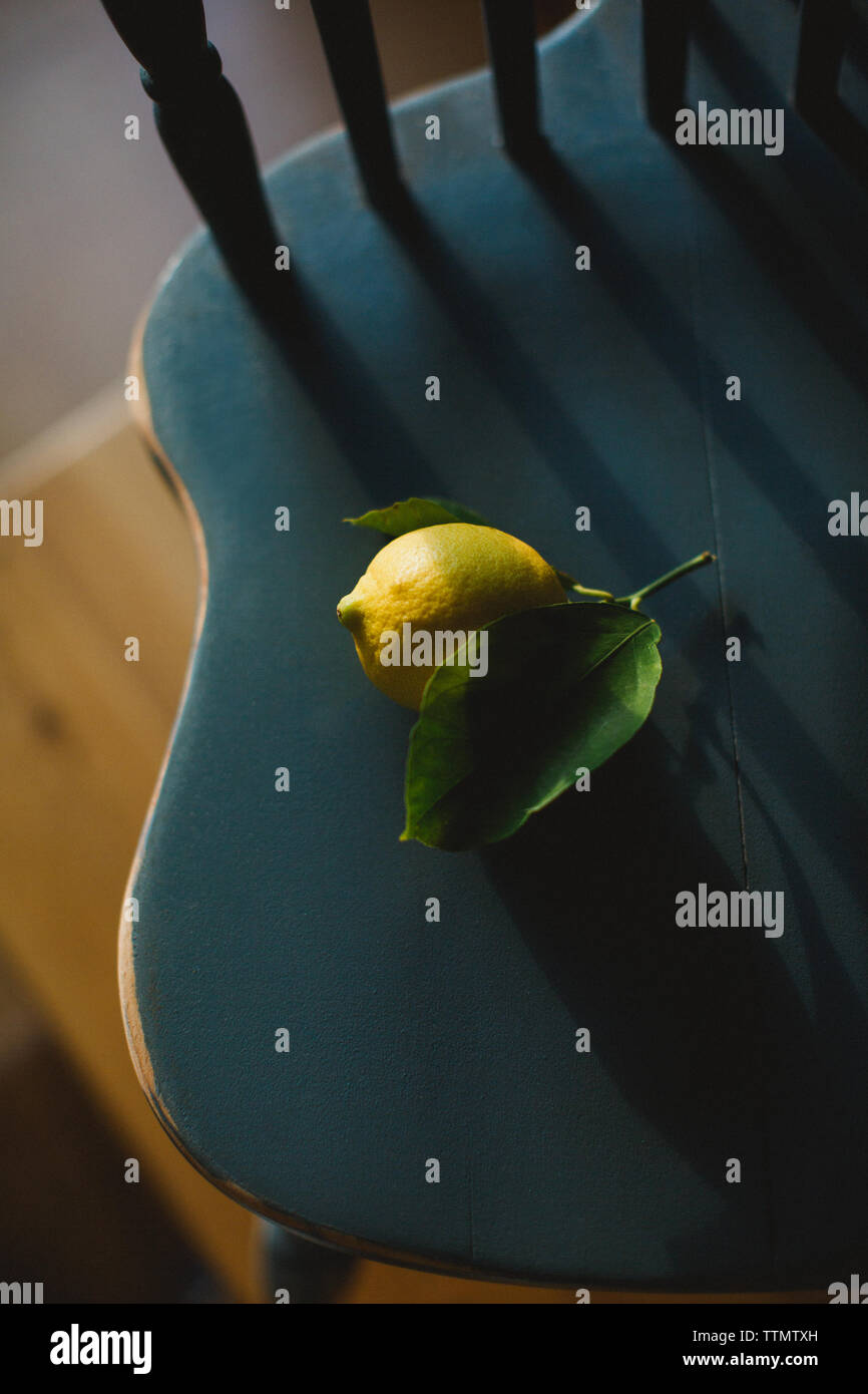 Yellow Lemon with green leaf laid on top of a blue chair Stock Photo ...