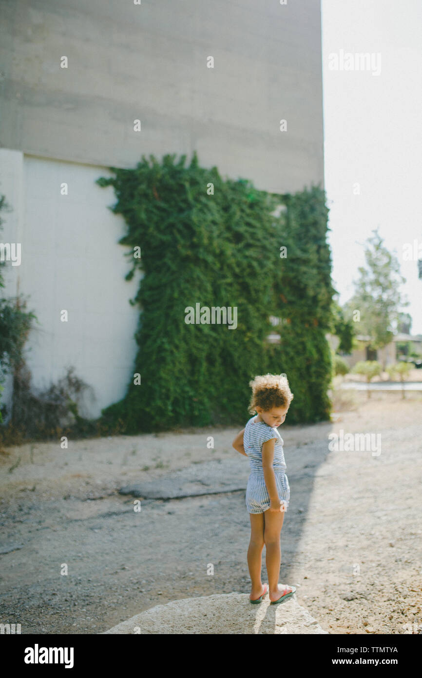 A young girl standing on a stone outside a big old silo Stock Photo - Alamy