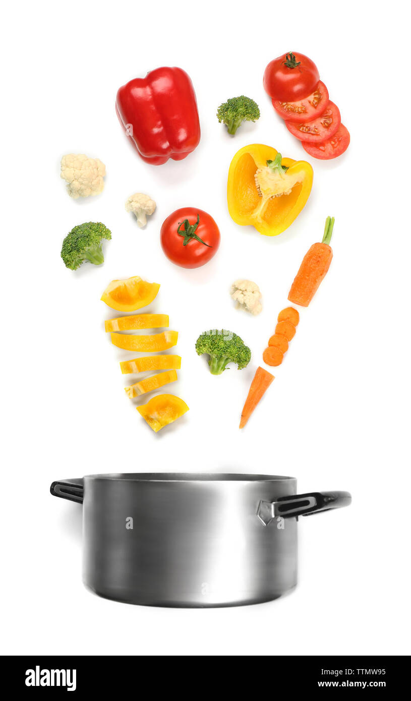 Fresh vegetables falling into a casserole pot on white background Stock ...