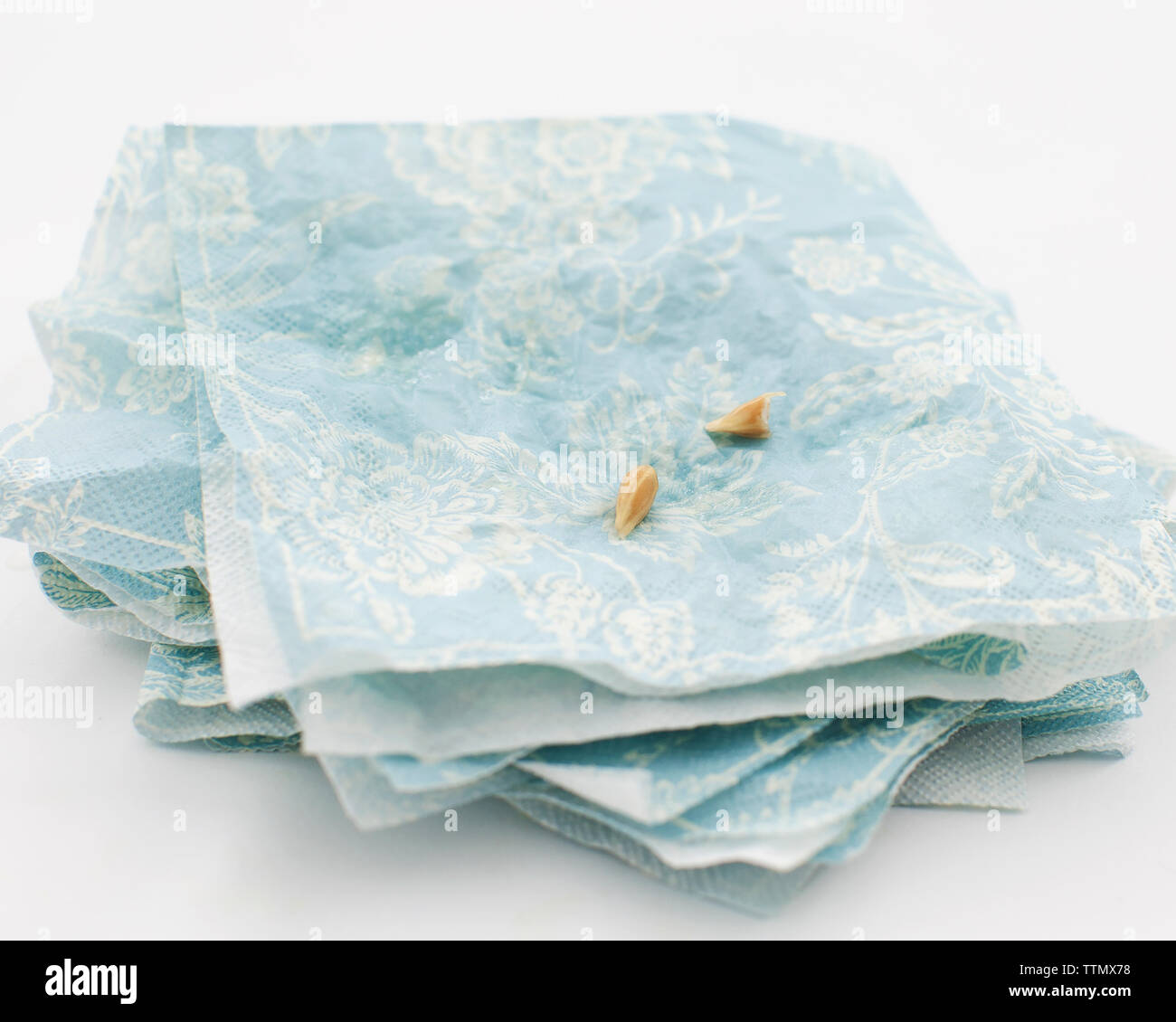High angle view of tissue papers with seeds on white background Stock ...