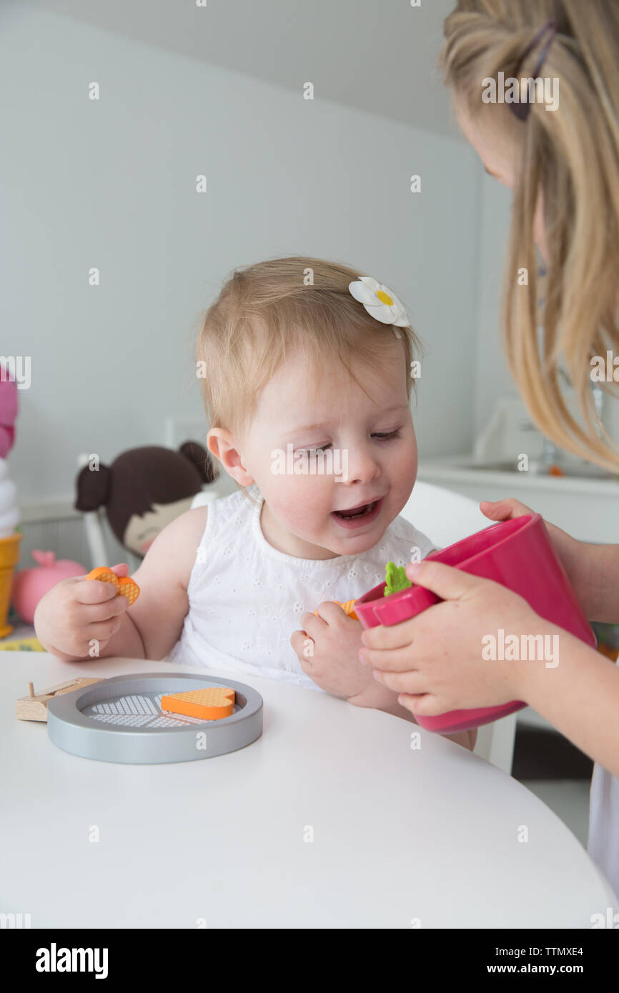 Sisters playing at playhouse Stock Photo - Alamy
