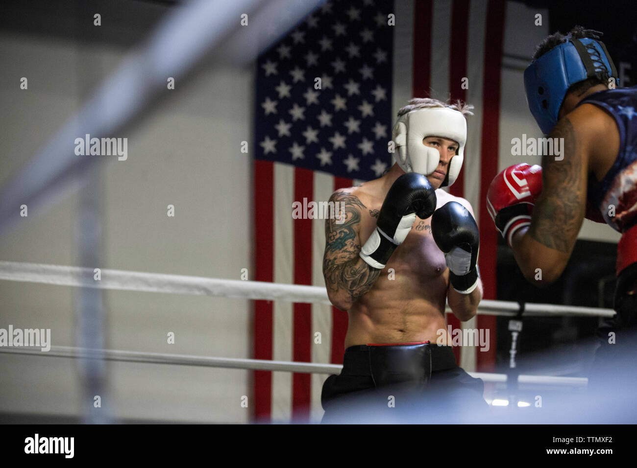 Low angle view of boxers fighting in boxing ring in gym against ...