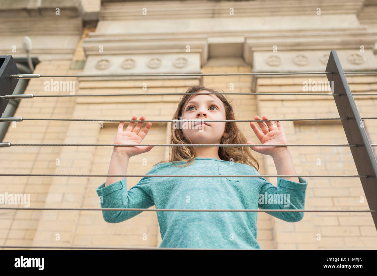 Girl looking through fence hi-res stock photography and images - Alamy