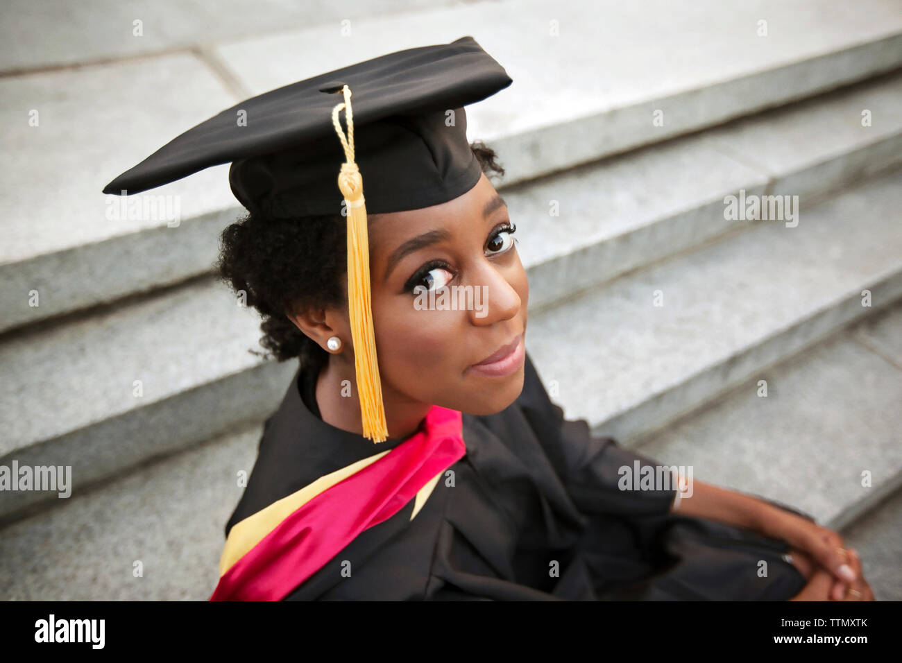 Portrait of woman wearing graduation gown Stock Photo - Alamy