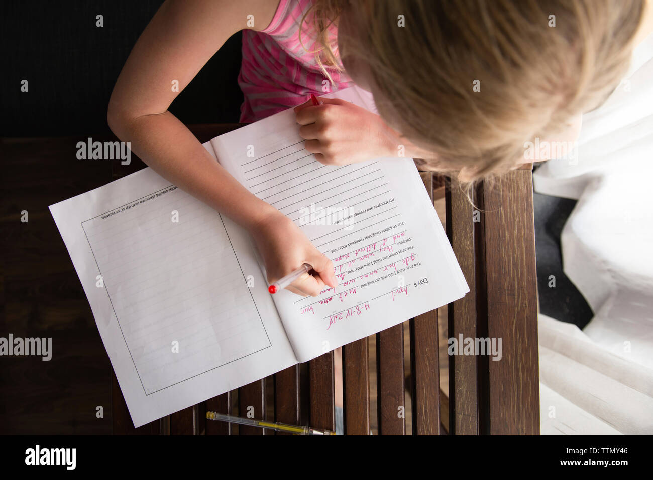 High angle view of girl writing homework while sitting at home Stock ...