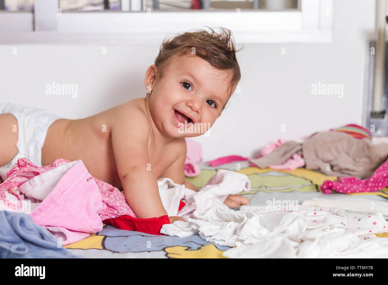 messy girl clothes on top of her mother's bed Stock Photo - Alamy