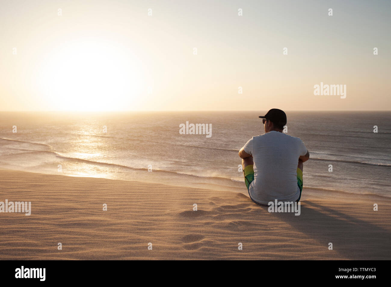 Man sitting on beach Stock Photo - Alamy