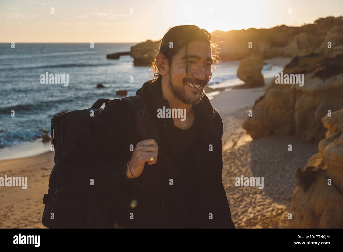 Smiling man standing backpack hi-res stock photography and images - Alamy