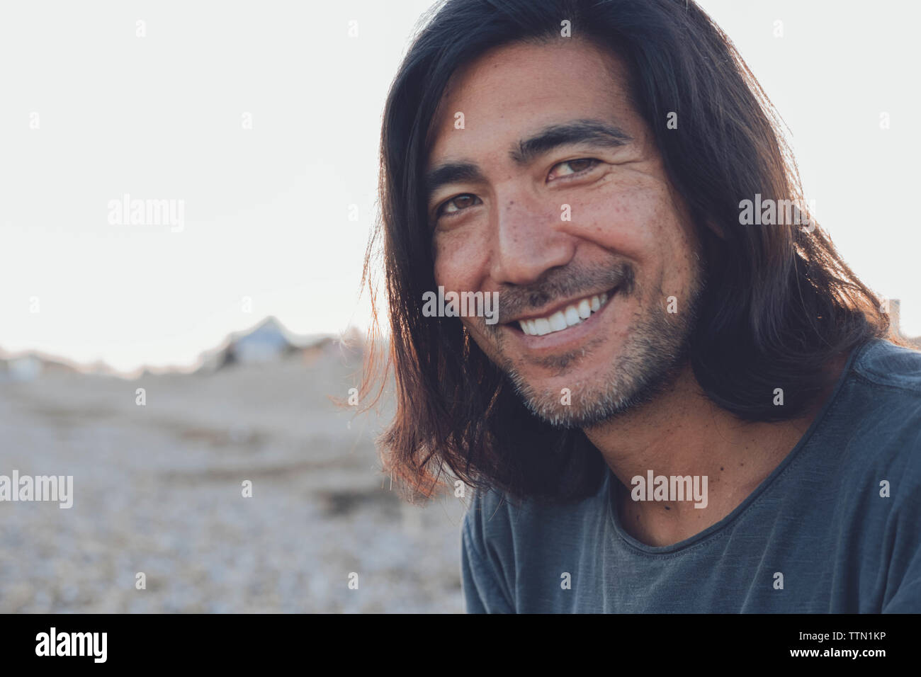 Person smiling at the camera on the beach Stock Photo - Alamy