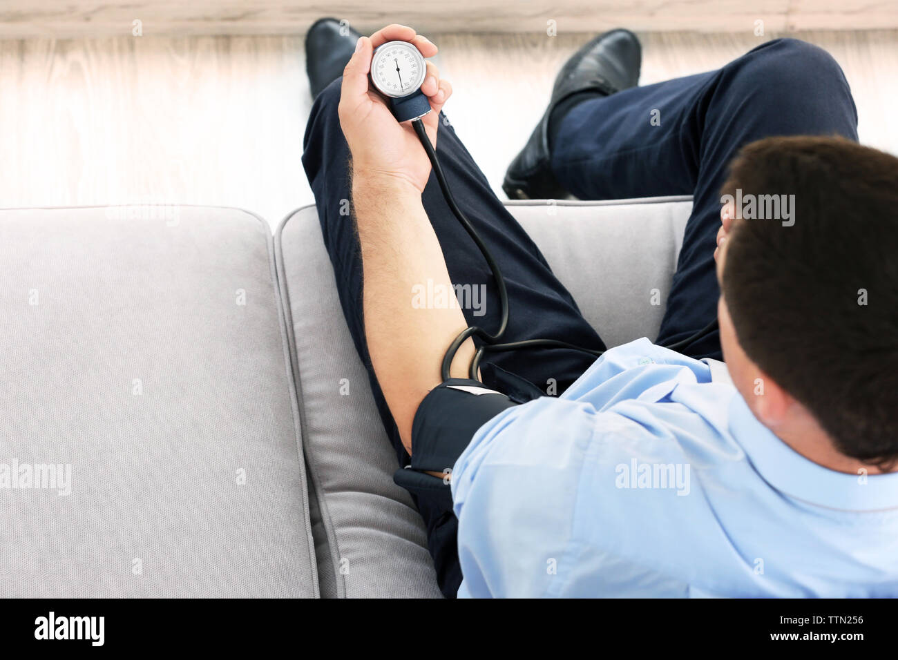 Man measuring blood pressure himself with tonometer Stock Photo - Alamy