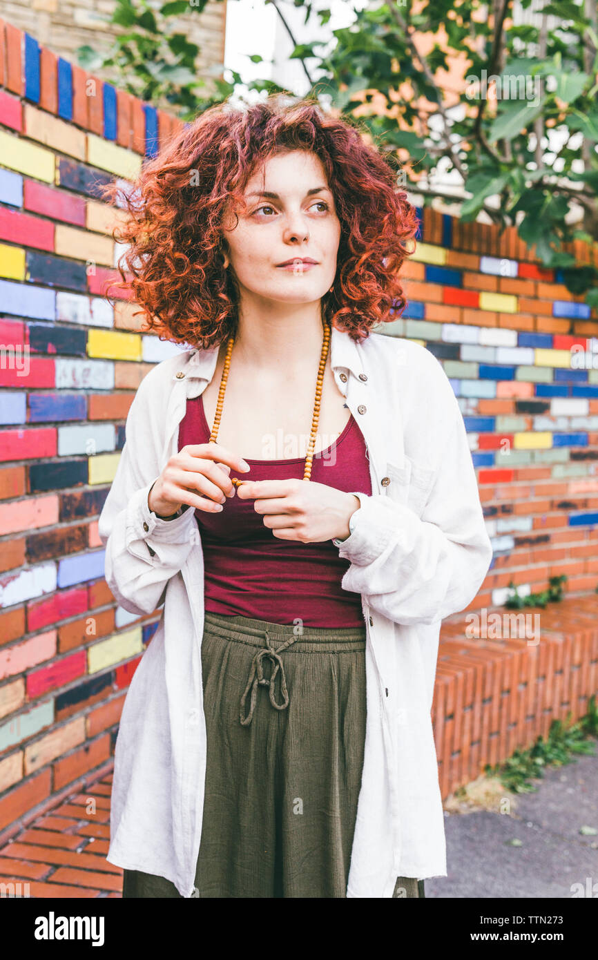 Woman standing against brick wall hi-res stock photography and images ...